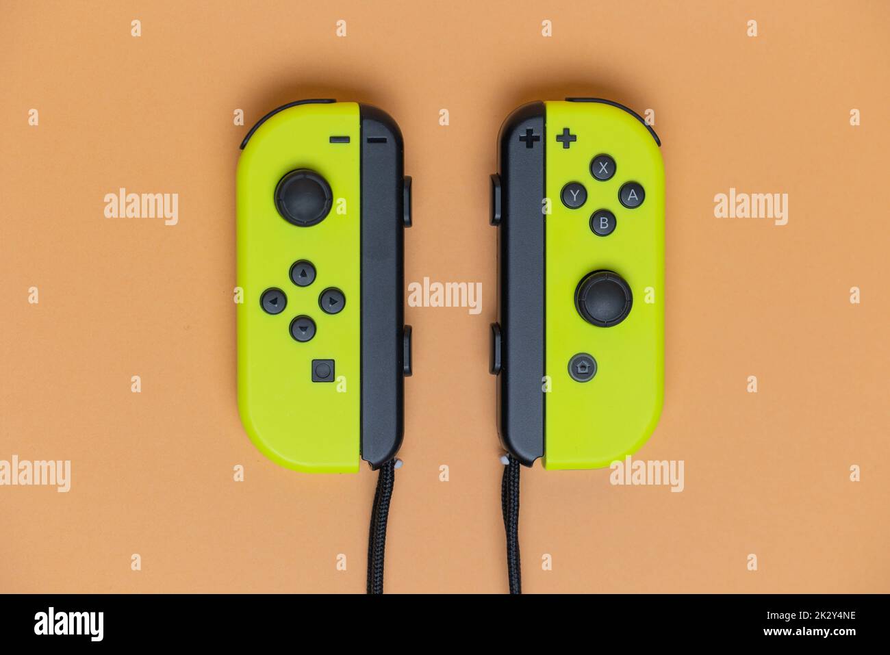 The top view of a pair of yellow Nintendo Joycons over the orange ...