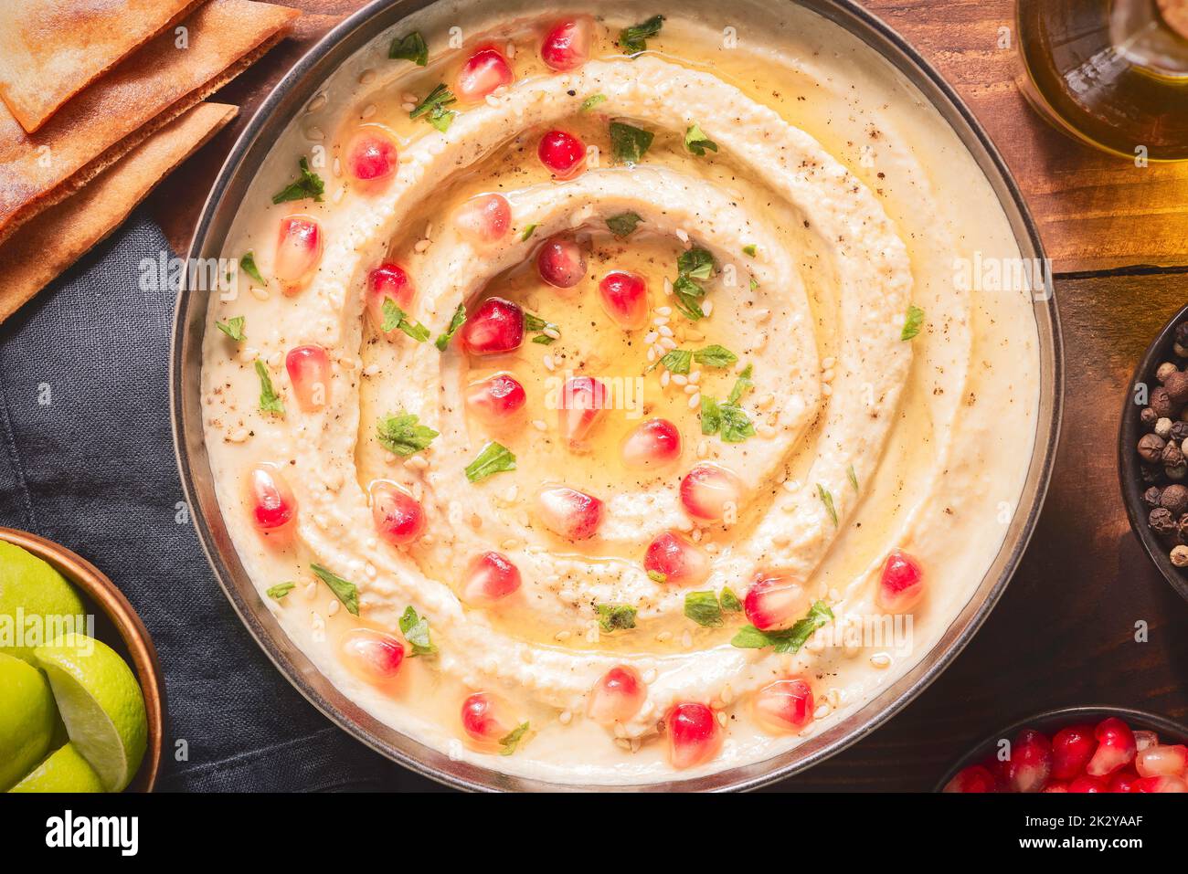 Arabic cuisine; Traditional creamy hummus dip in dark bowl. Topped with ...