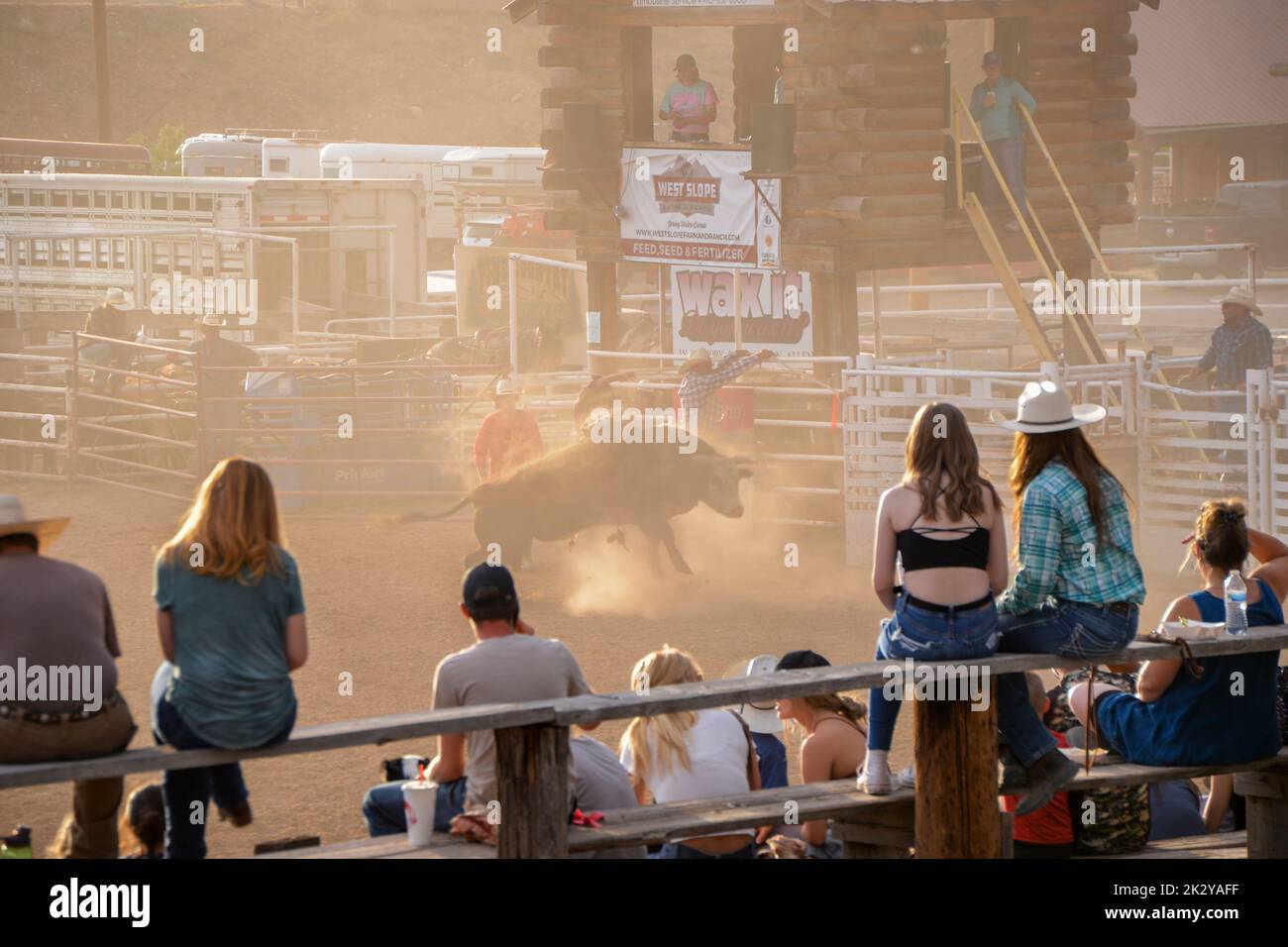 Spectators sitting on wooden benches enjoy the bull riding event at the ...