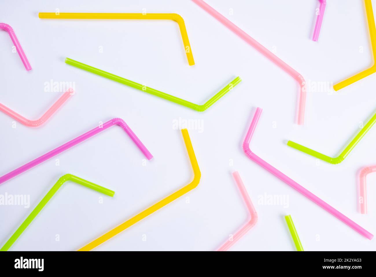 multi-colored cocktail straws on a white background, top view, the ...