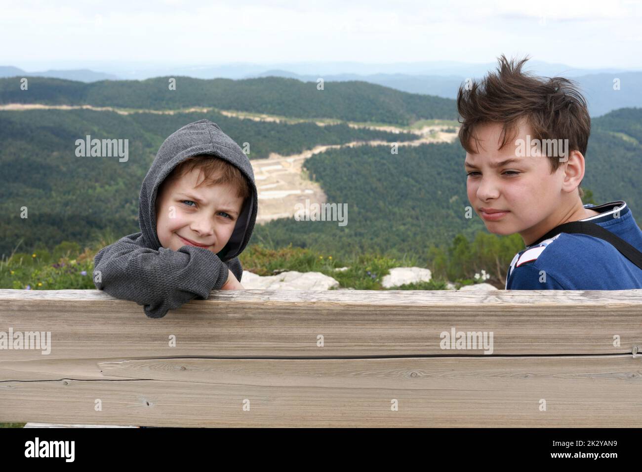Two brothers sitting on bench on Lago-Naki plateau, Adygea Stock Photo ...