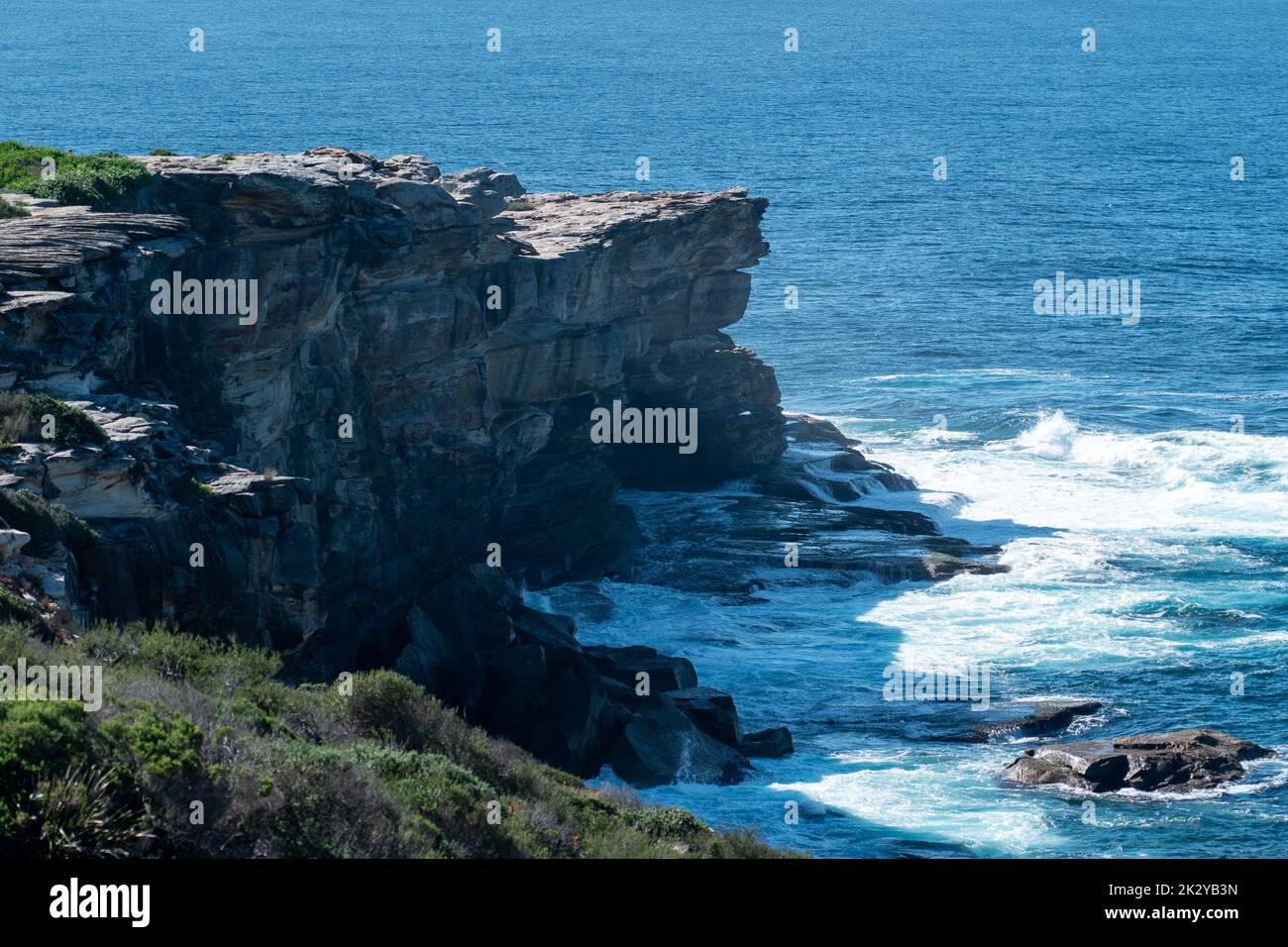 A view of a cliff with strong waves hitting the bottom of the sea rock ...