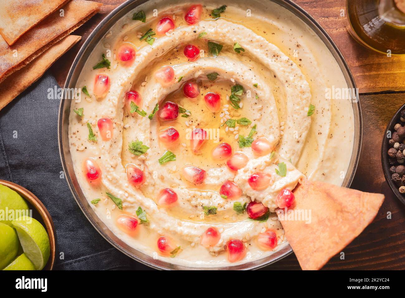 Arabic cuisine; Traditional creamy hummus dip in dark bowl. Topped with ...