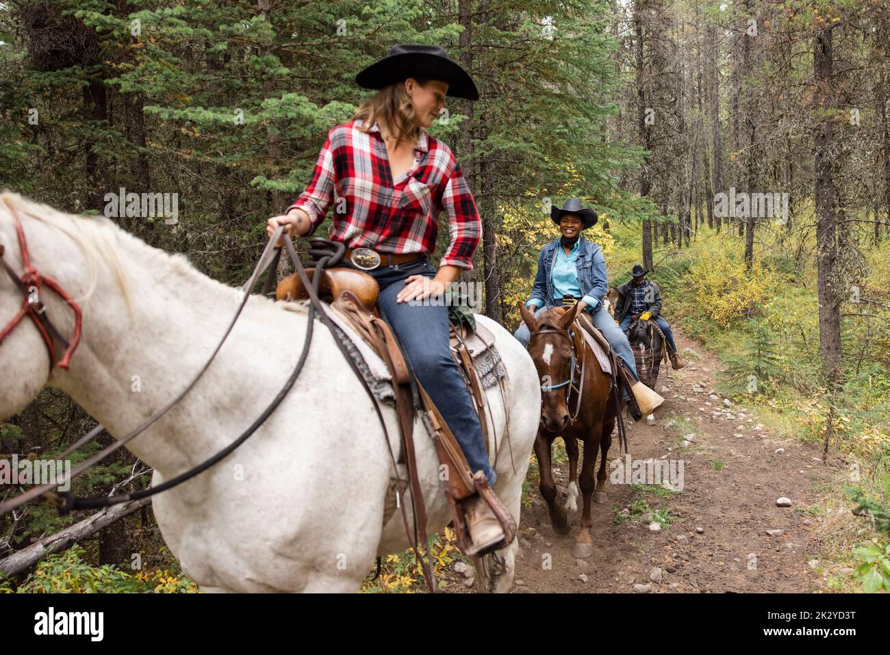 Cowboy looking back riding horse hi-res stock photography and images ...