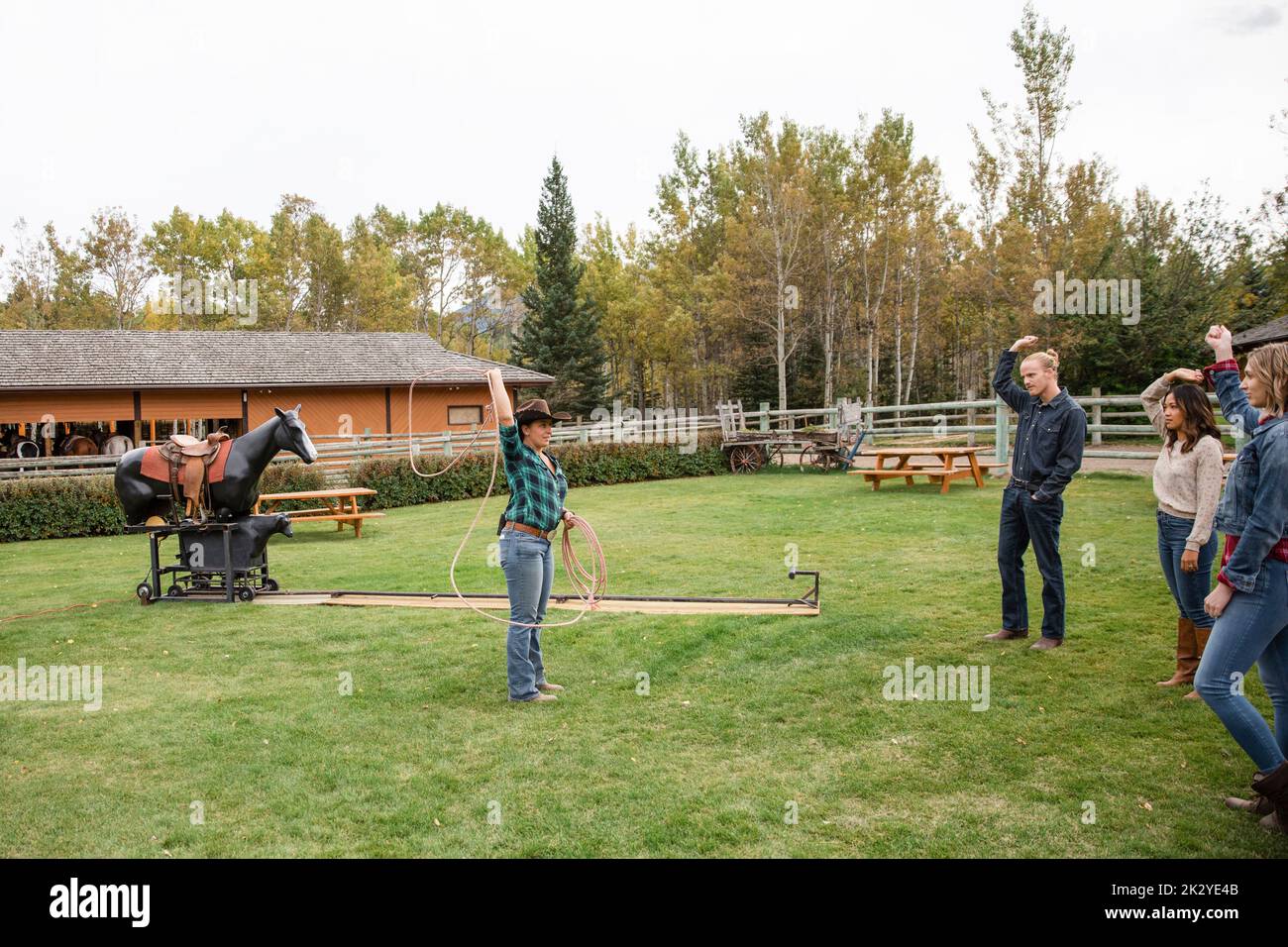 Female rancher teaching calf roping to young friends on ranch Stock ...