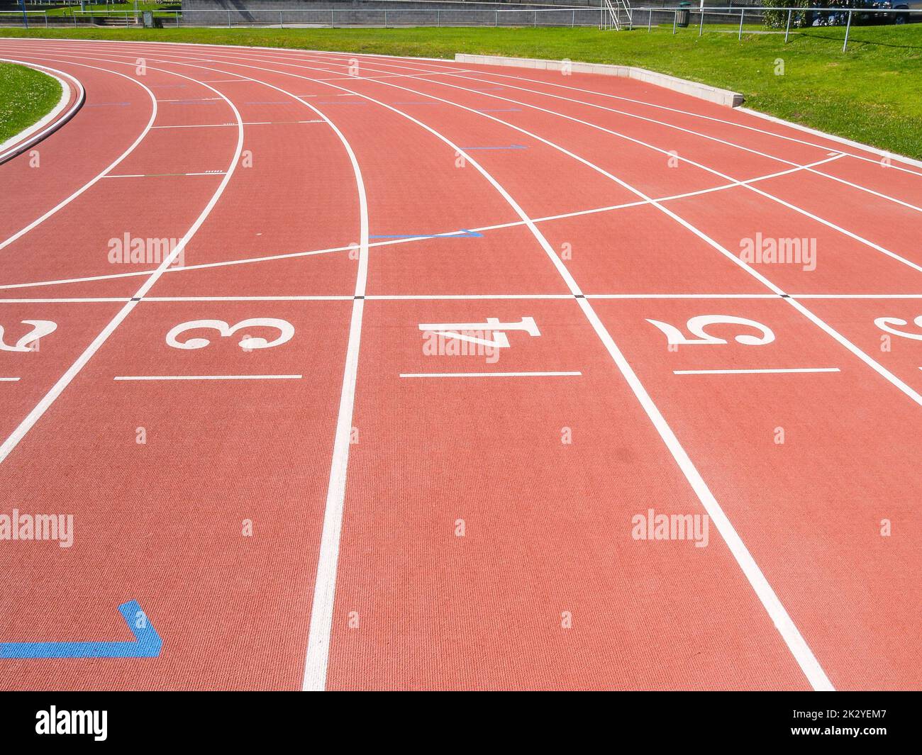 White numbered lanes on red synthetic running track Stock Photo - Alamy