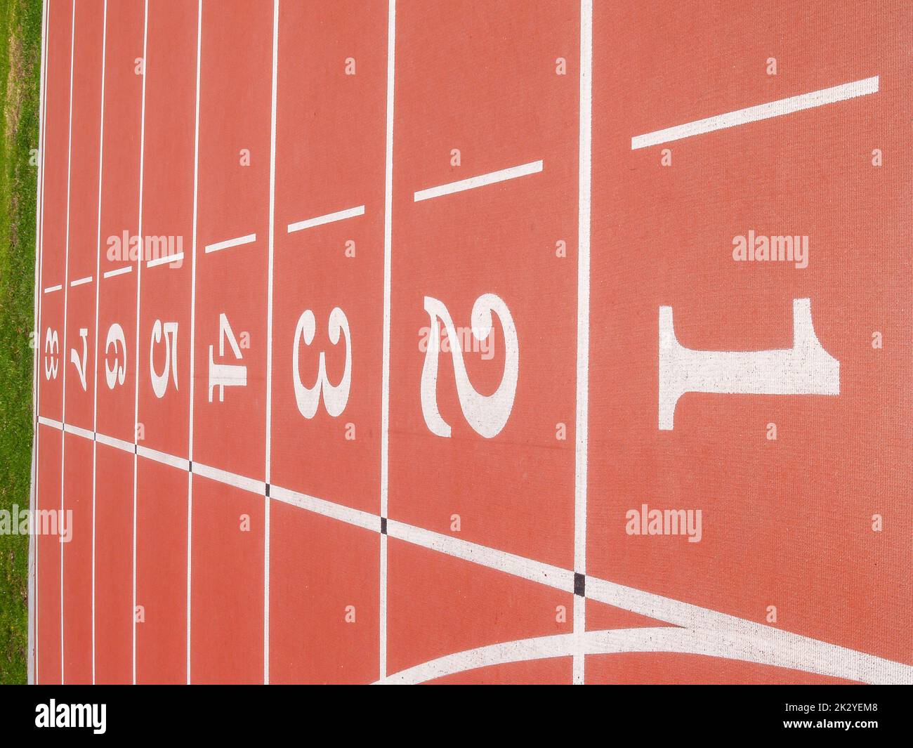 White numbered lanes on red synthetic running track Stock Photo - Alamy
