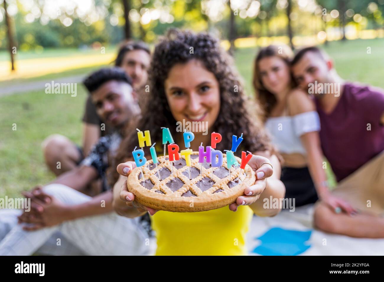 multiethnic group of millennial friends celebrating a birthday with a ...
