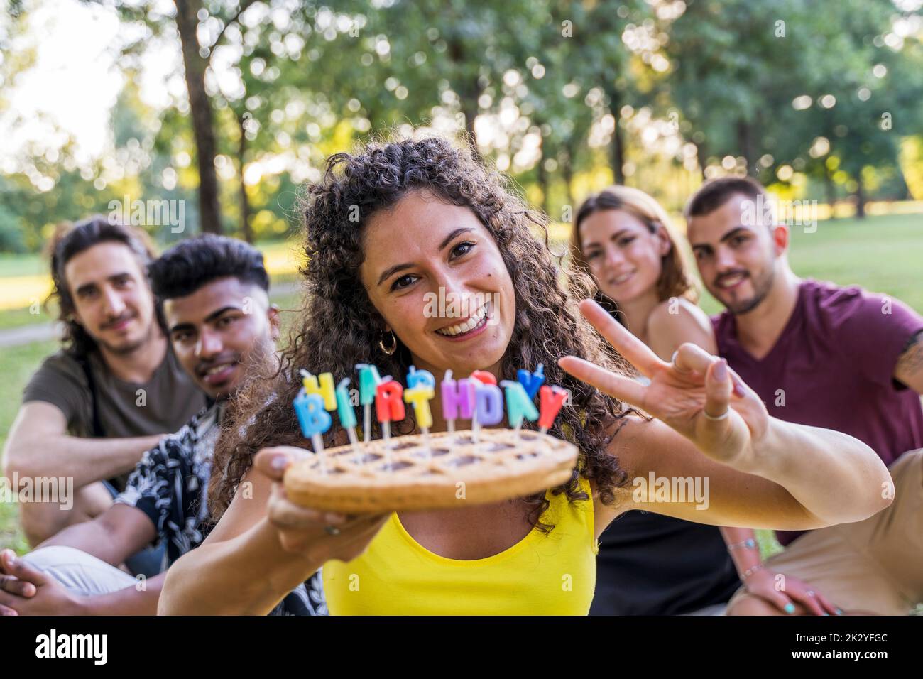 multiethnic group of millennial friends celebrating a birthday with a ...