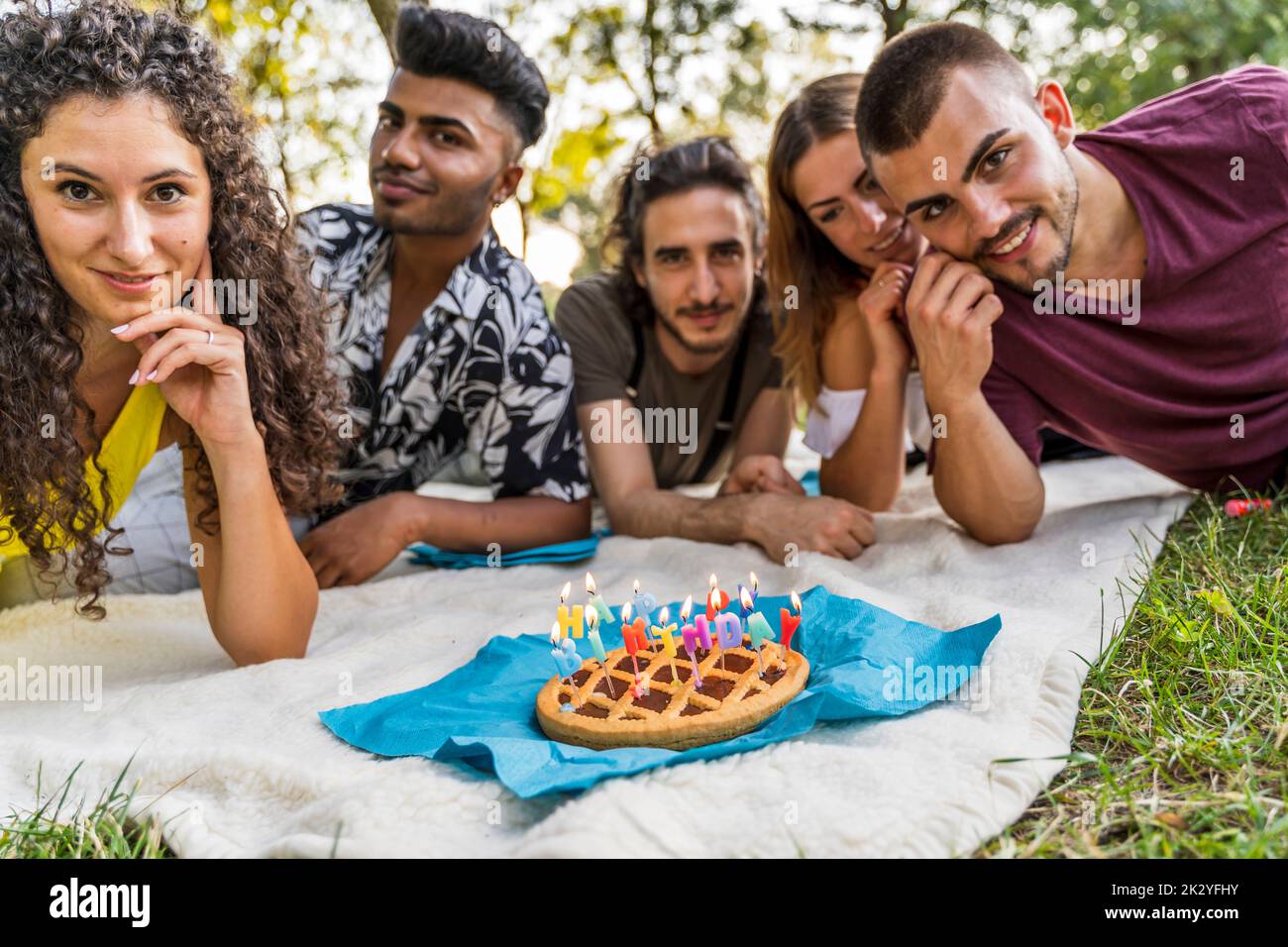 multiethnic group of millennial friends celebrating a birthday with a ...