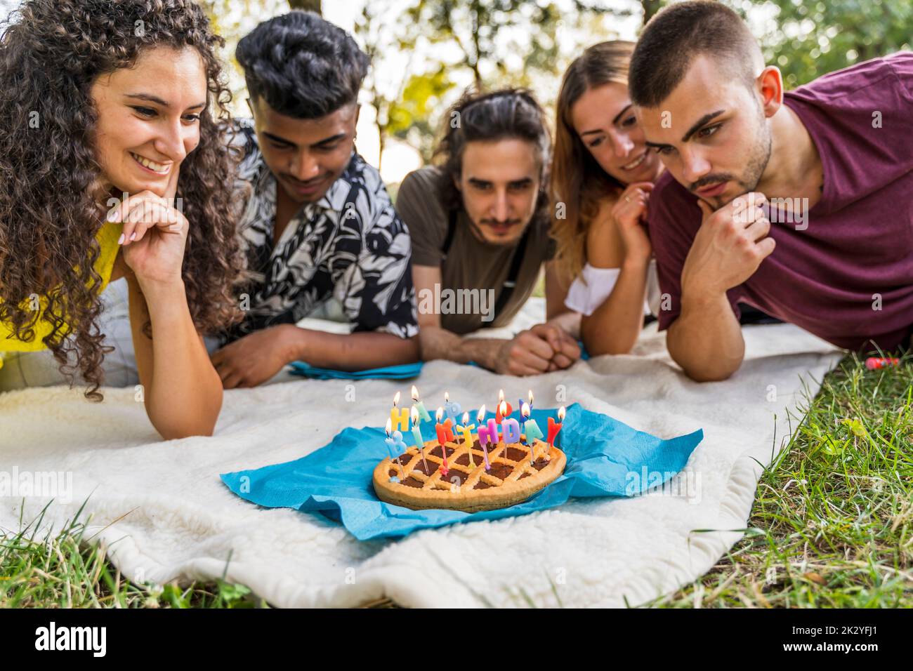 multiethnic group of millennial friends celebrating a birthday with a ...
