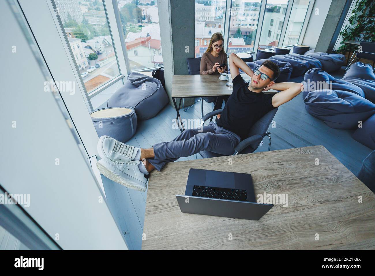 A young employee manager is resting at the workplace near the laptop ...