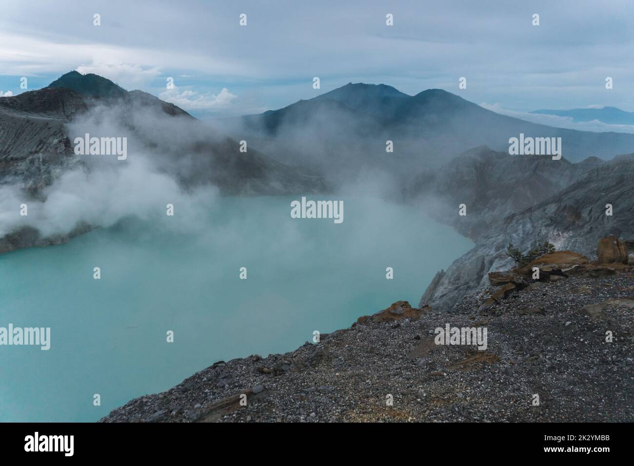 An aerial view of a blue acid lake with sulfur steam near Mount Ijen ...