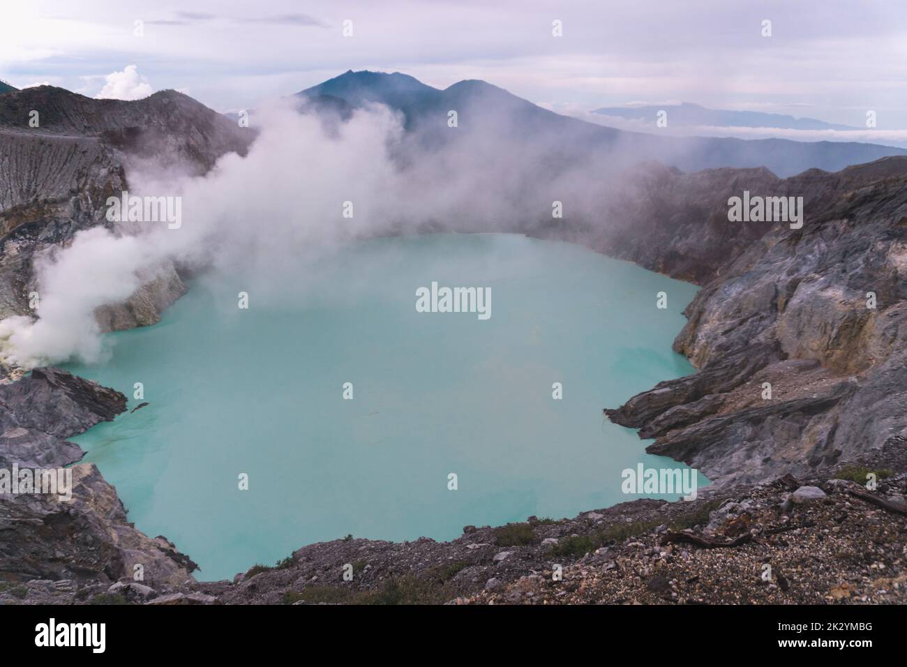 An aerial view of a blue acid lake with sulfur steam near Mount Ijen ...