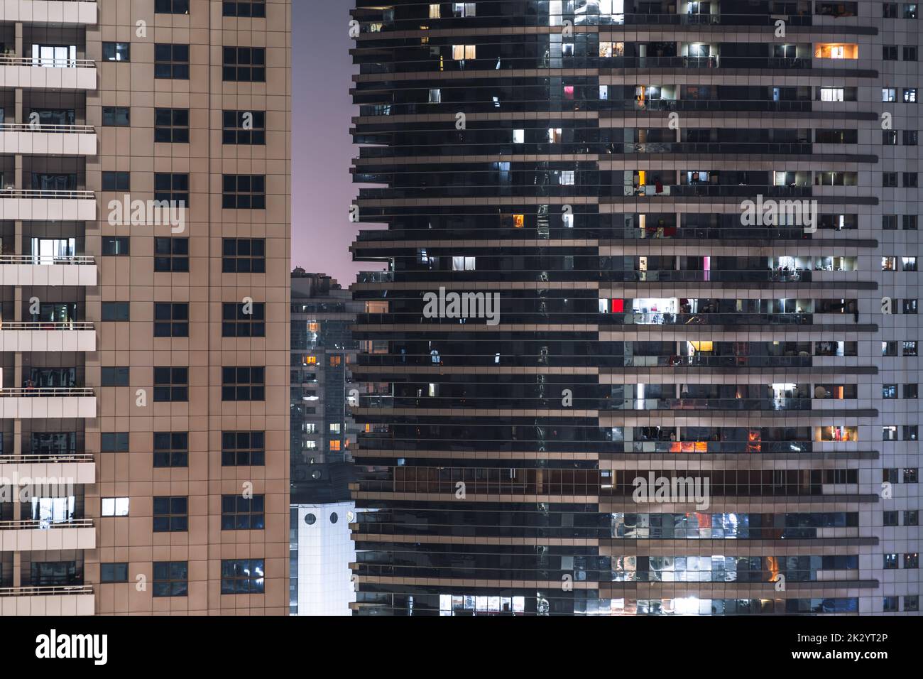 Facades of two big residential houses, high-rises at night with ...