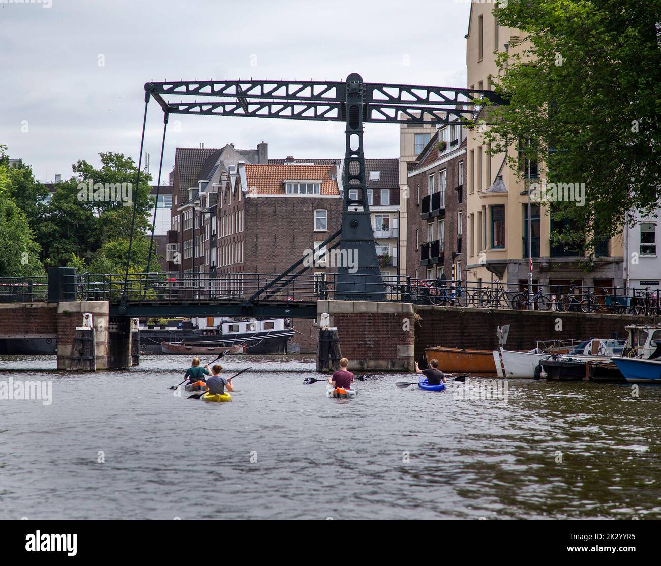 Kayakers paddling towards a bridge in an Amsterdam canal Stock Photo ...