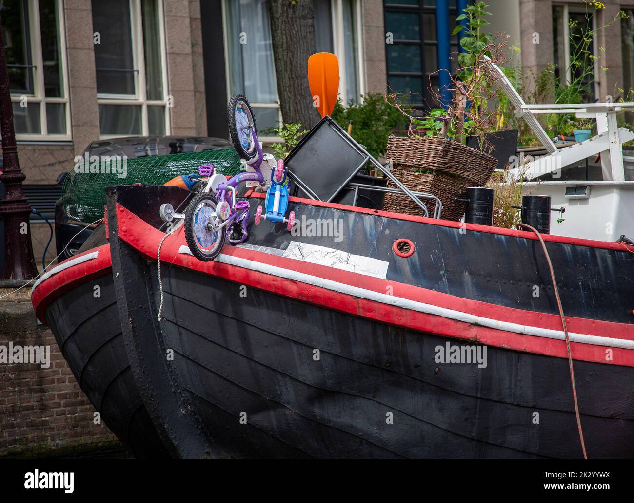 Barge on the side of a canal in Amsterdam Stock Photo - Alamy