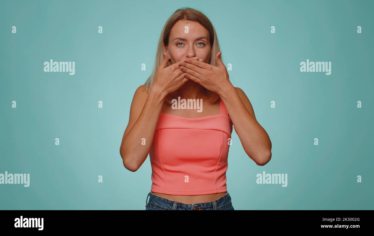 I will not say anyone. Frightened sincere woman closing her mouth with ...