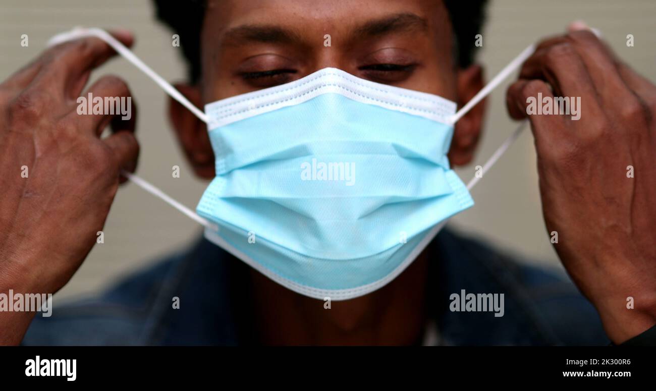 African man removing face mask feeling relief. End of pandemic concept ...