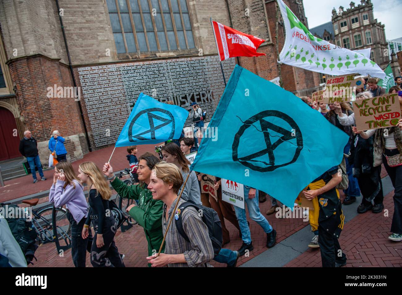 Protesters are seen holding flags with the symbol of the climate ...