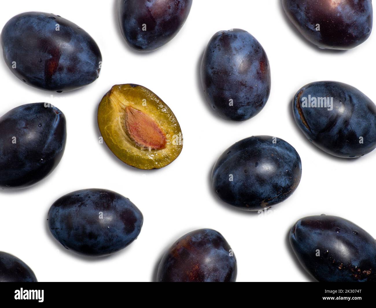 Plums on a white background. Juicy sliced plum. Stone in yellow pulp ...