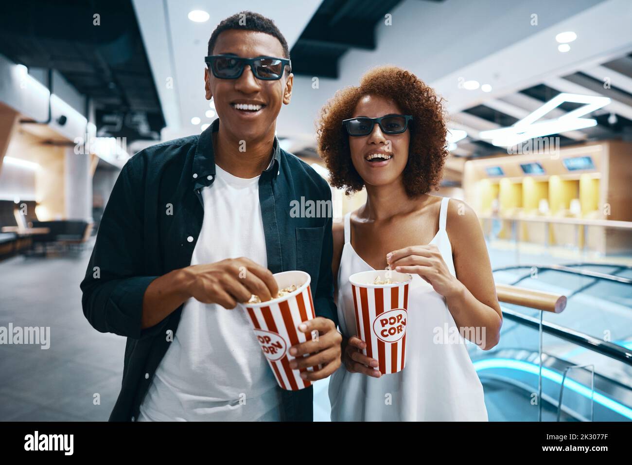 A couple in love, friends watching a movie with popcorn in the cinema ...