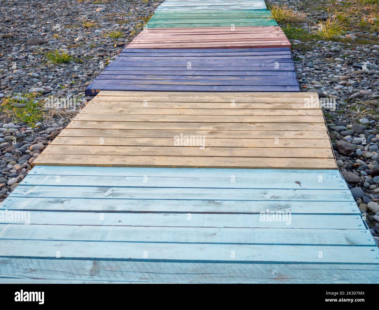 Multi-colored decking on a pebble beach. The path to the shore from ...
