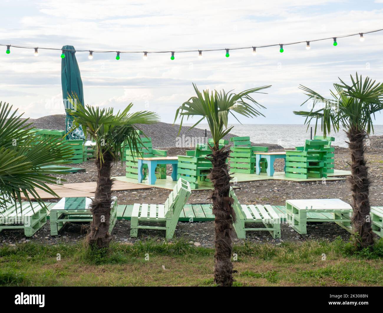 The interior of a street restaurant among palm trees. Cafe in green ...