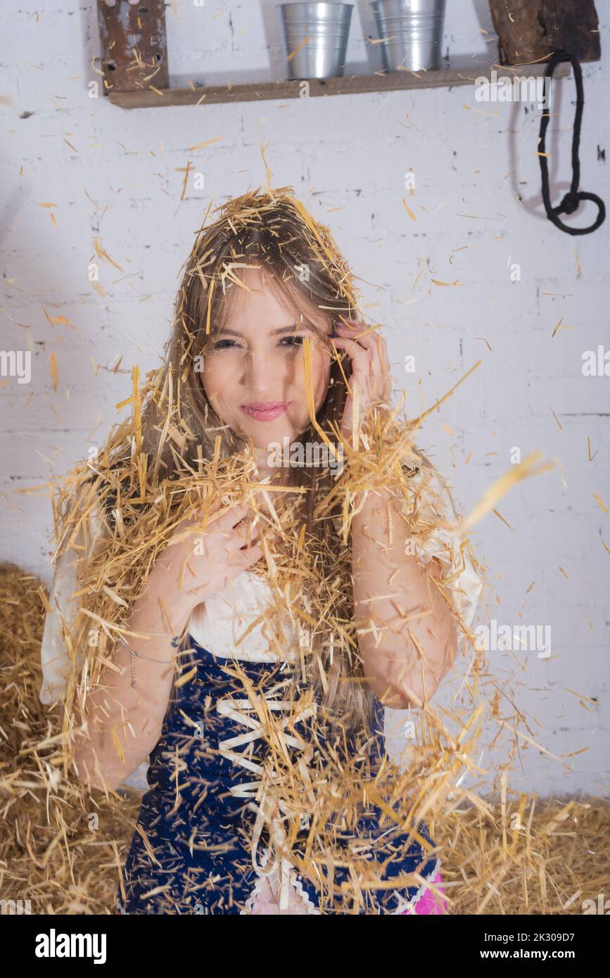 Beautiful Young Woman Dressed In A Farmers Outfit In The Barn Playing