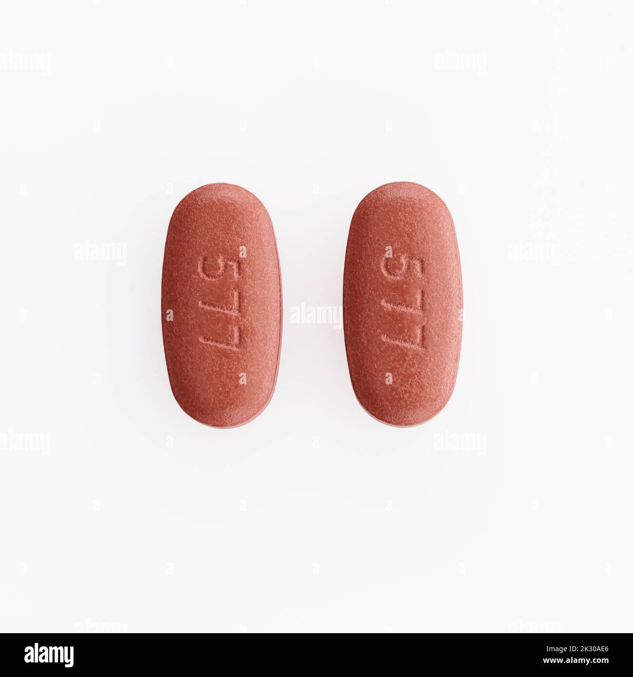 A closeup shot of two oval medical pills isolated on a white background ...