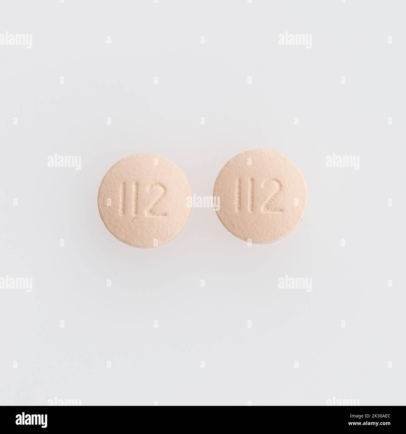 A closeup shot of two round medical pills isolated on a white ...