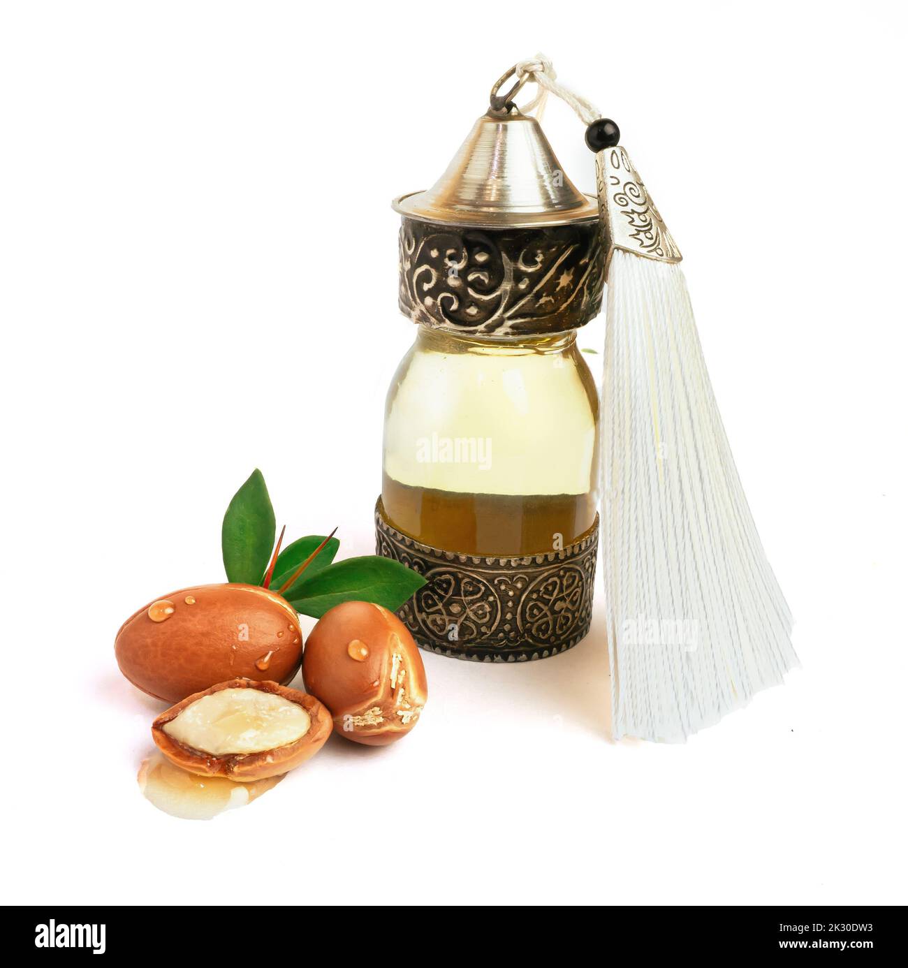 Argan oil in a oriental glass and metal bottle and argan nuts with ...