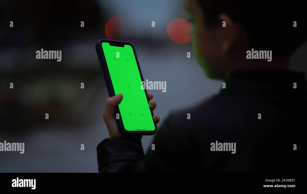 Boy tapping on the green screen of his smartphone. A child with a phone ...