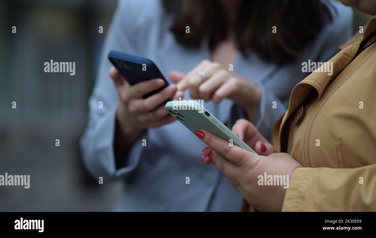 Close up focus on females hands using phones. Two women with ...