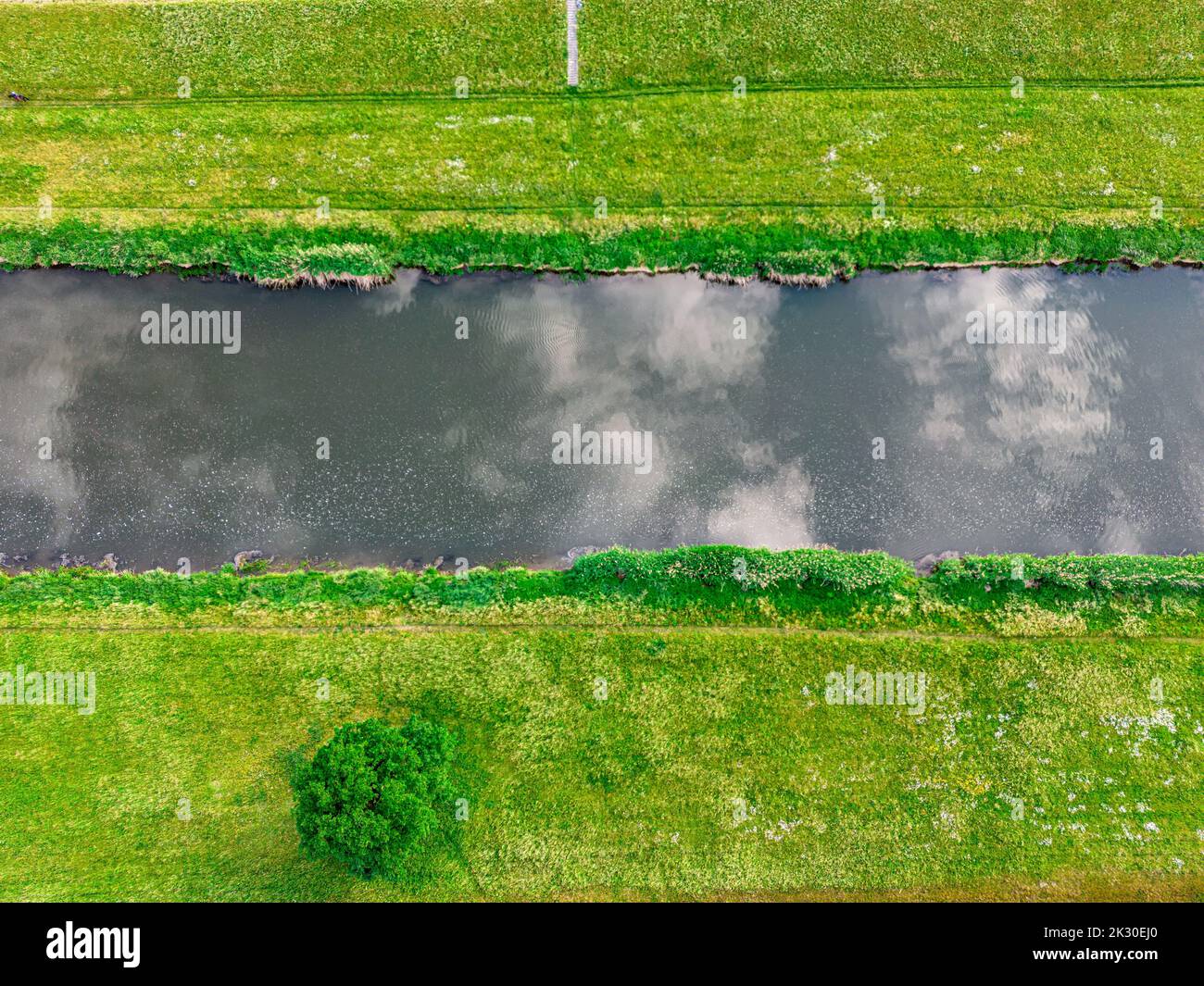 An aerial view of parallel lines of a water canal and stripes of grass ...