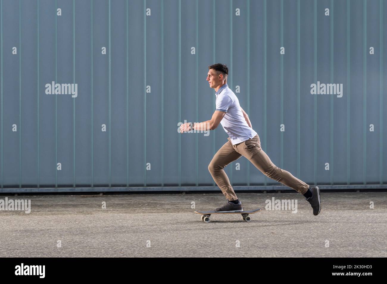 Young man skateboarding in front of wall Stock Photo - Alamy
