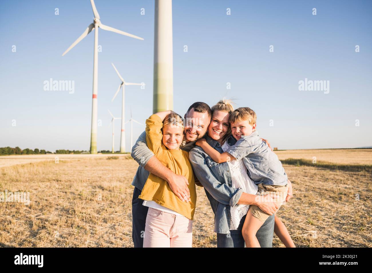 Happy family standing in wind park embracing children Stock Photo - Alamy