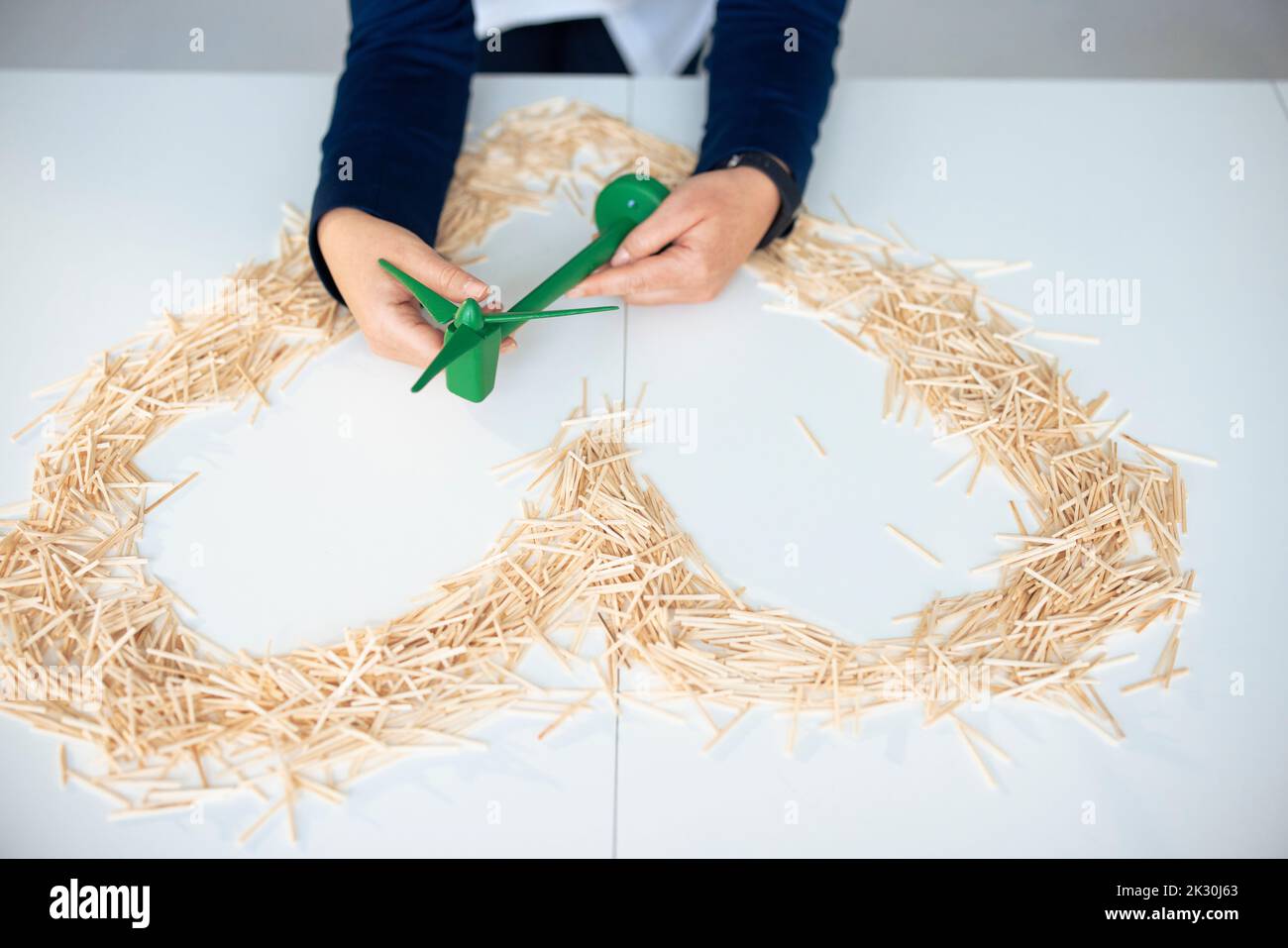 Hands of businesswoman holding model of wind turbine on heart shape ...