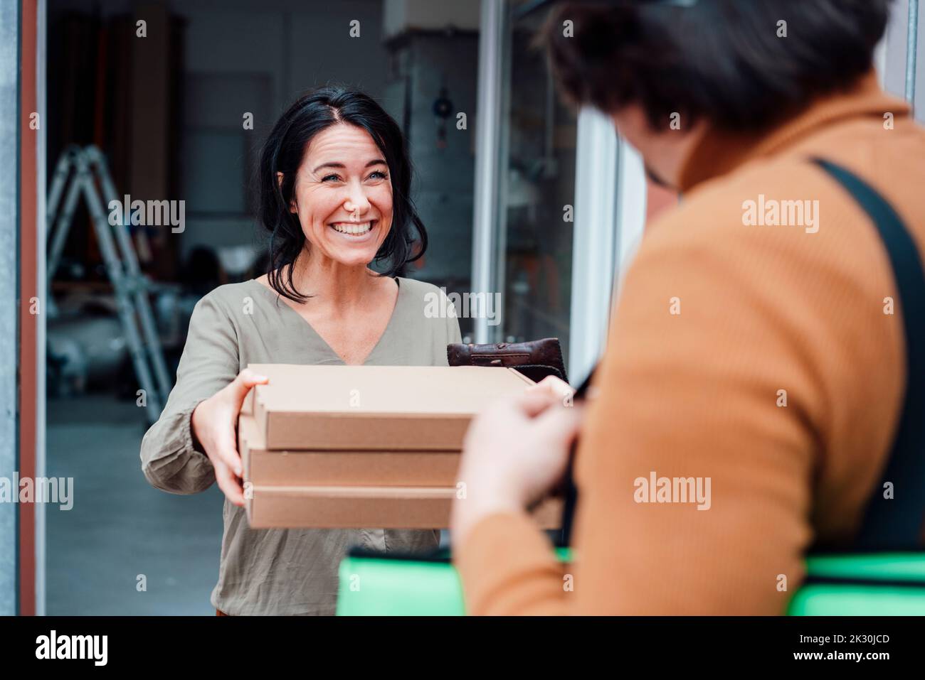 Happy woman receiving parcel from delivery man Stock Photo - Alamy