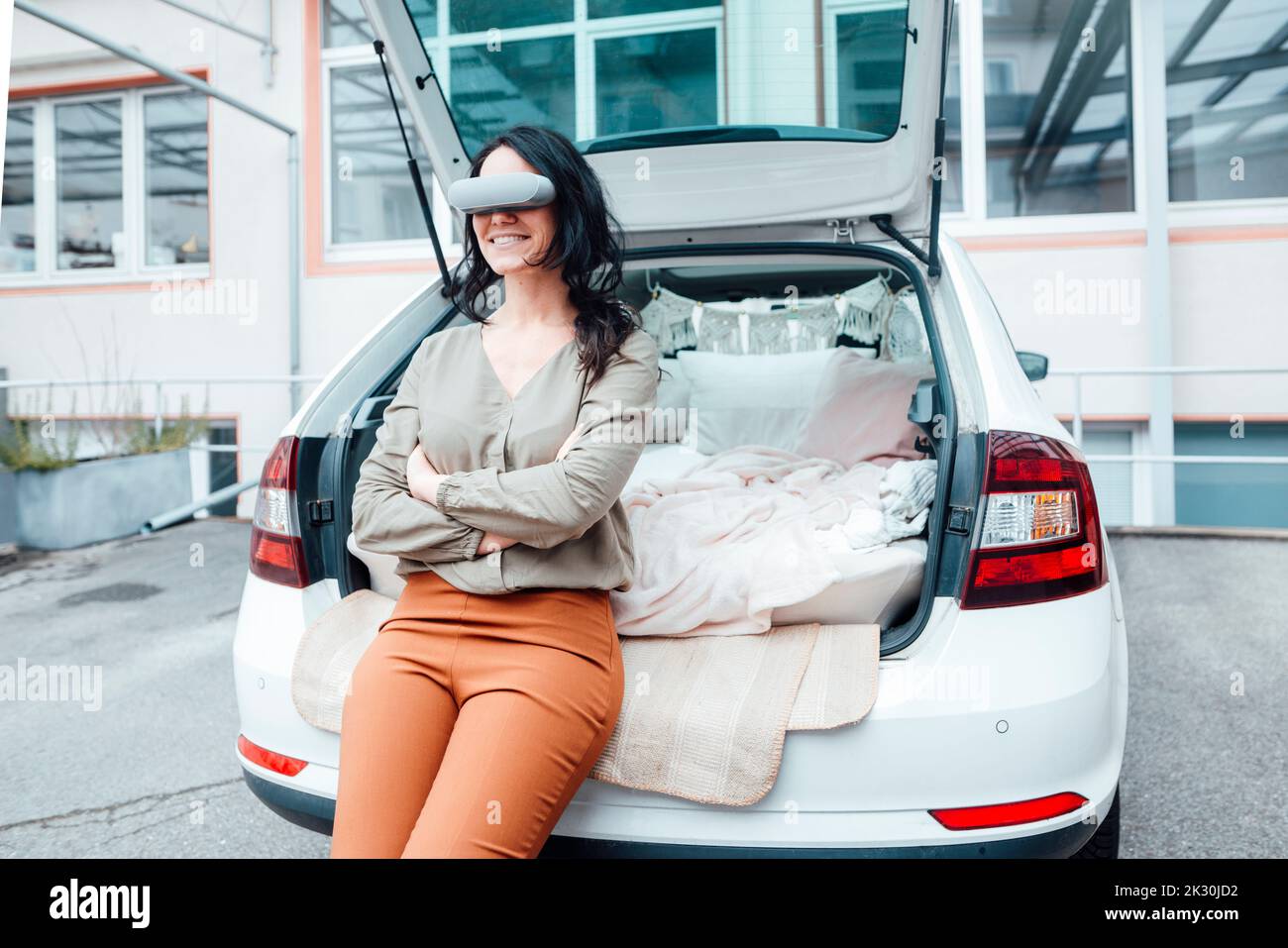 Smiling woman wearing virtual reality simulator sitting with arms ...