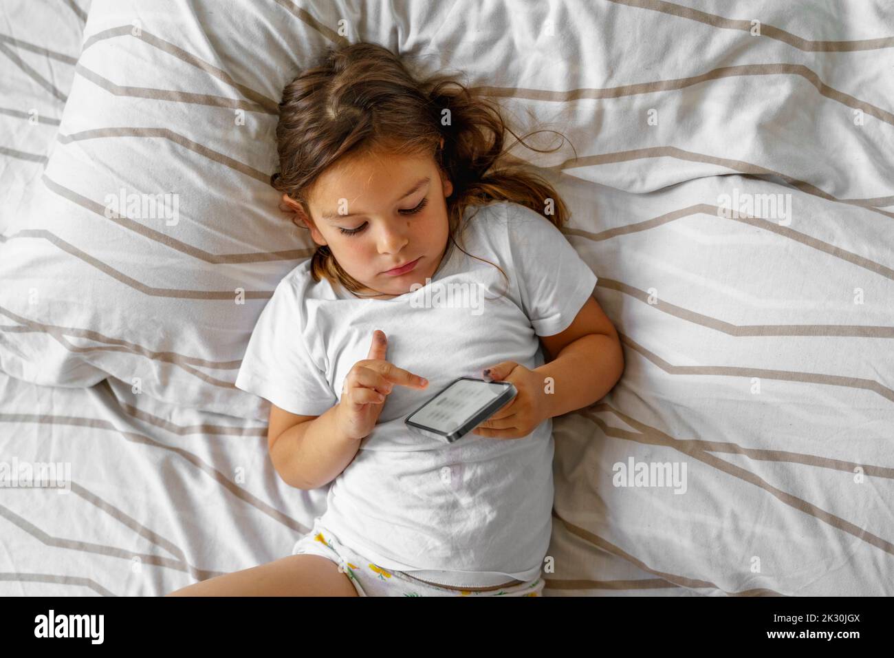 Girl with phone bed hi-res stock photography and images - Alamy
