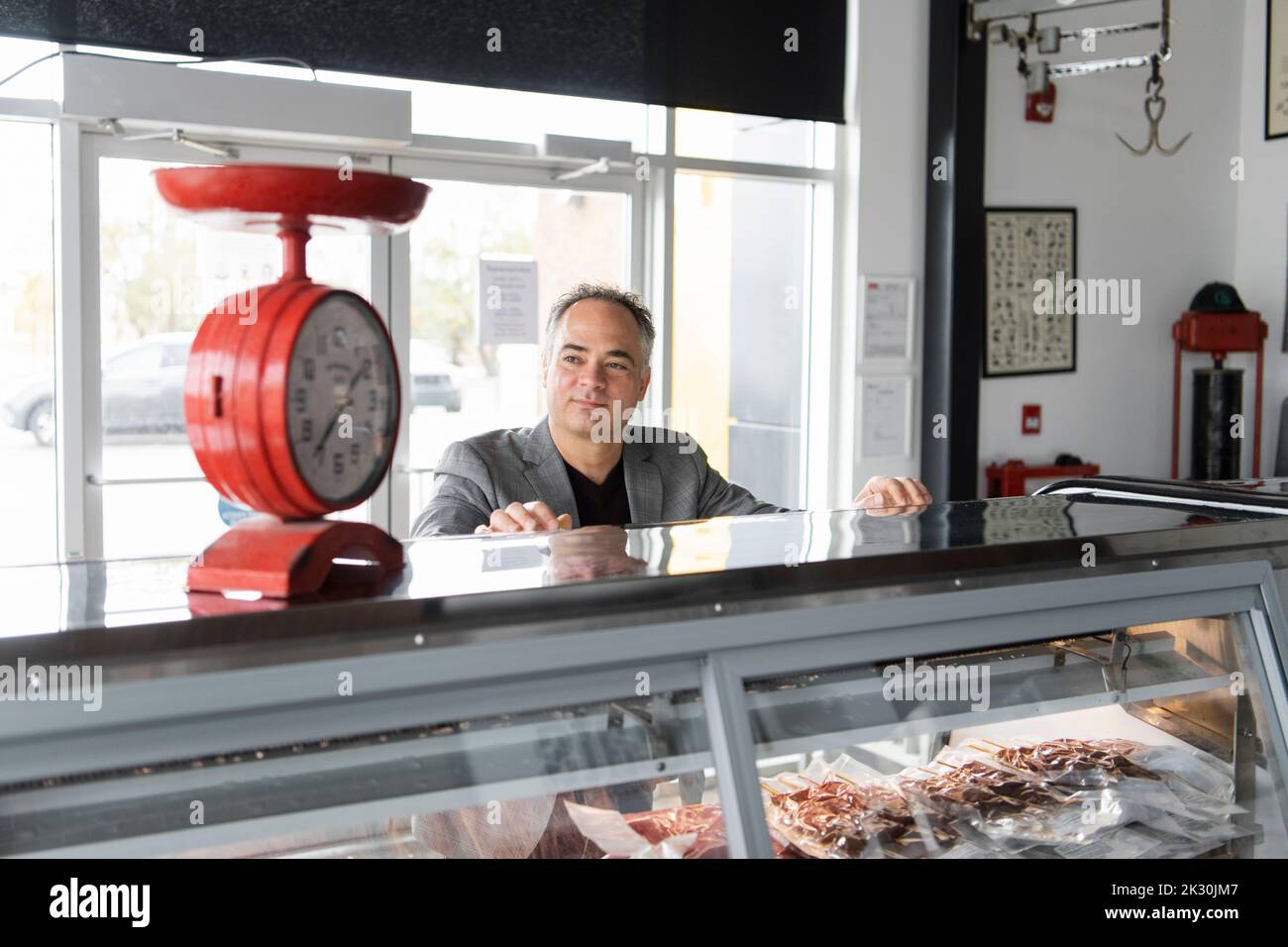 Customer standing at counter in butcher's shop Stock Photo - Alamy