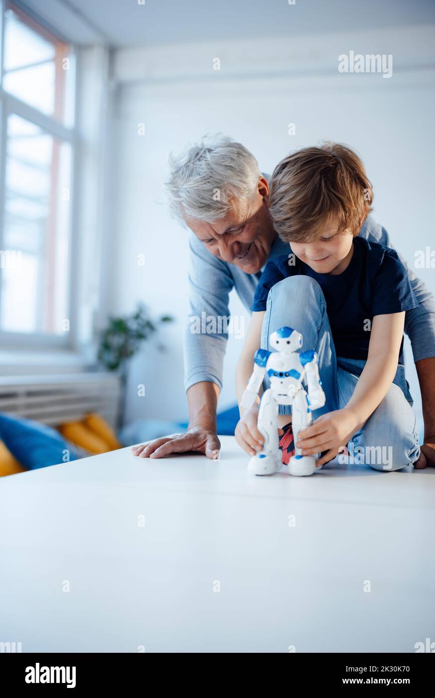 Boy playing with robot model by grandfather at home Stock Photo - Alamy