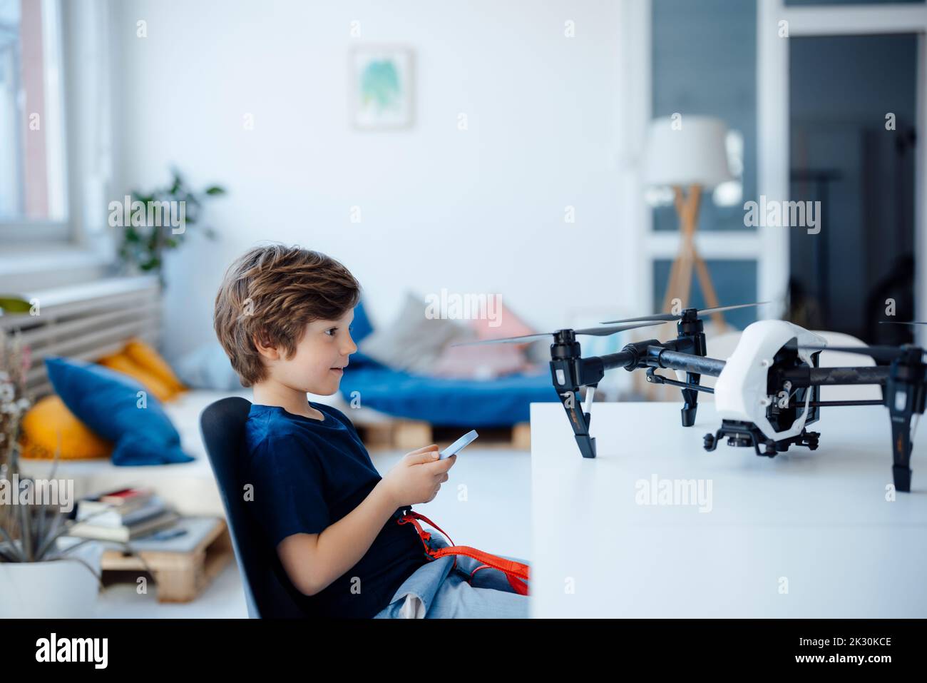 Boy playing with drone on table at home Stock Photo - Alamy