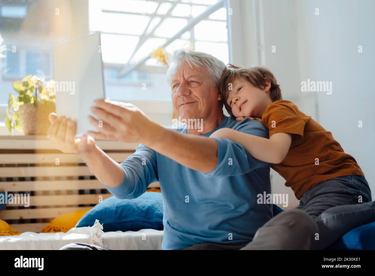 Senior man taking selfie with boy through tablet PC at home Stock Photo ...