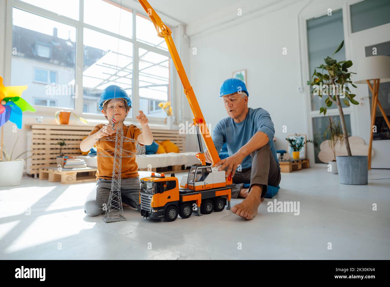 Boy imitating as engineer attaching electricity pylon model to toy ...