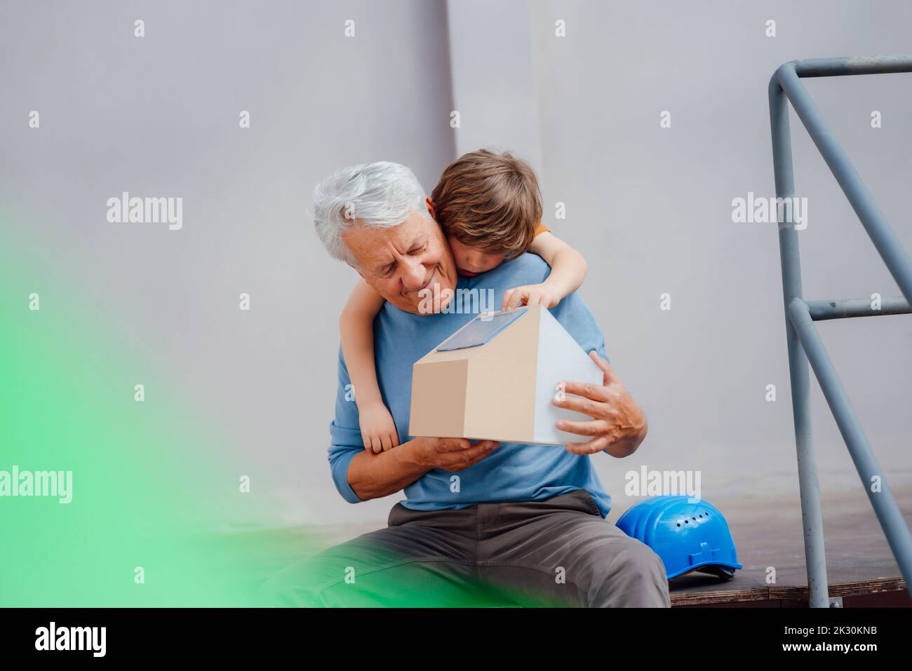 Boy examining solar model house with grandfather in front of wall Stock ...