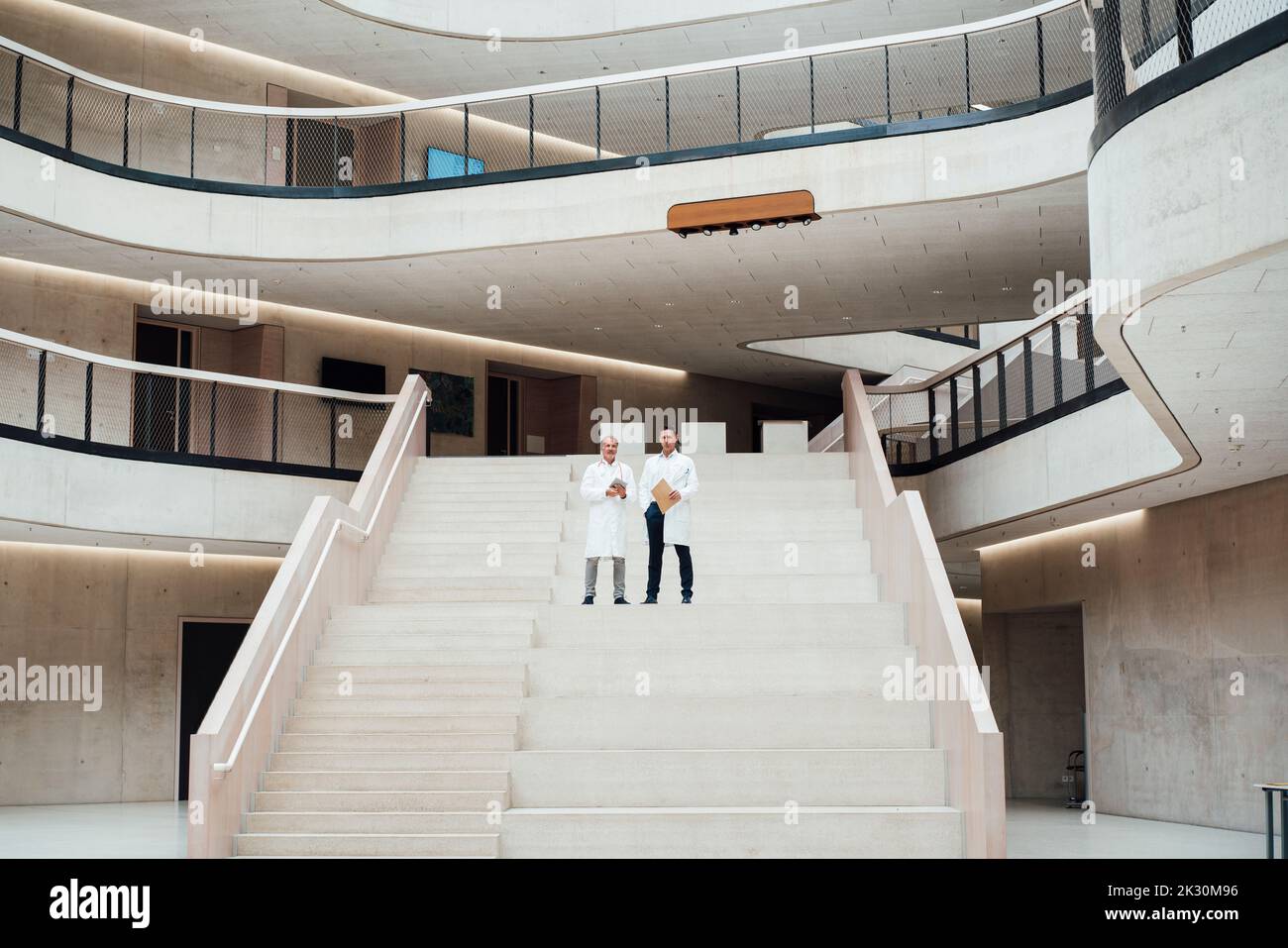 Doctors standing on staircase in hospital lobby Stock Photo - Alamy