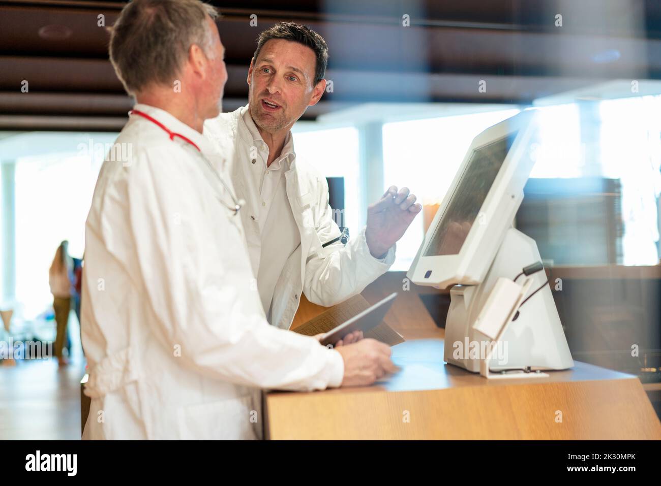 Doctors discussing by computer at hospital Stock Photo - Alamy