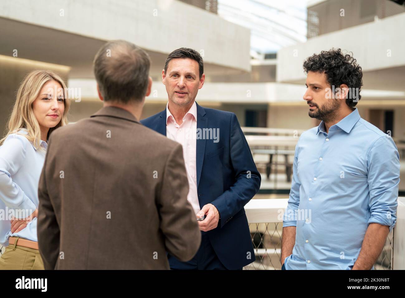 Business colleagues discussing strategy together in corridor Stock ...